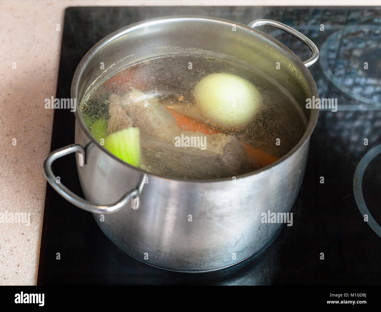 cooking soup - simmering meat broth in stockpot on ceramic cooker Stock ...