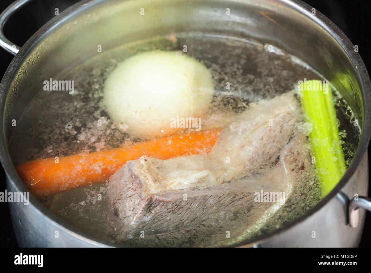 cooking soup - boiling beef broth in stew pan close up Stock Photo - Alamy