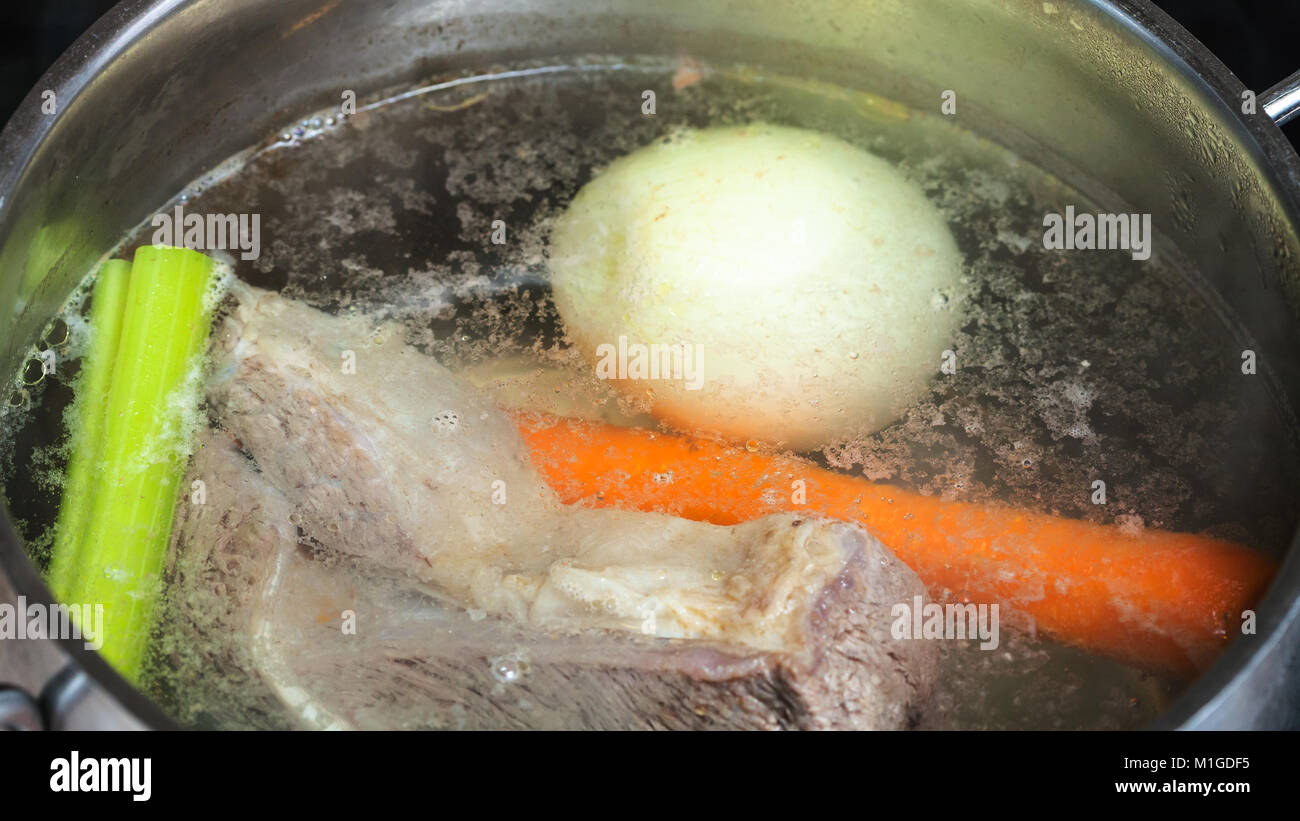 cooking soup - boiling beef stock in stewpan close up Stock Photo - Alamy