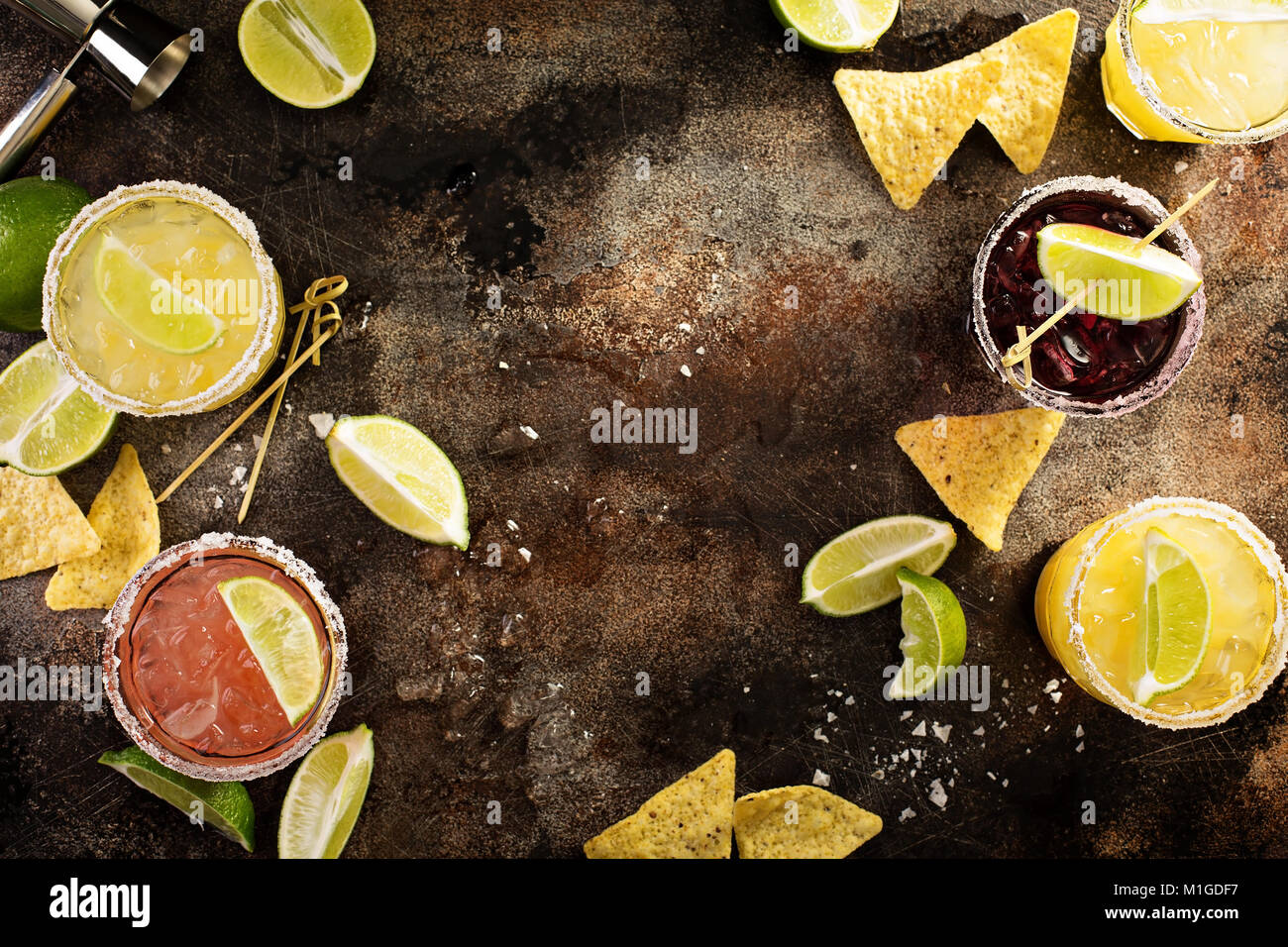 Variety of margarita cocktails with salted rim and lime on dark ...