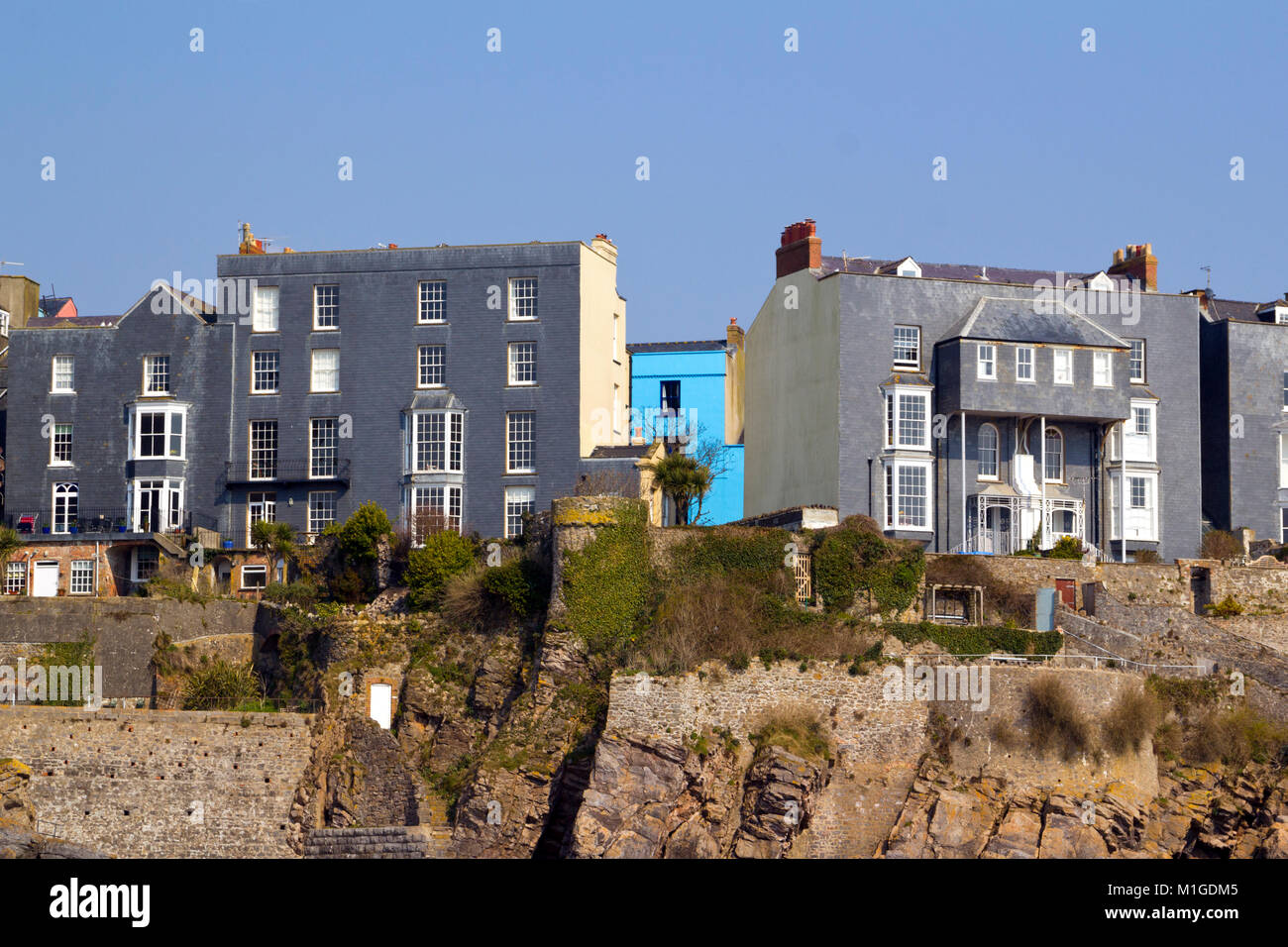 A vibrant blue painted house stands out amongst grey houses on the ...