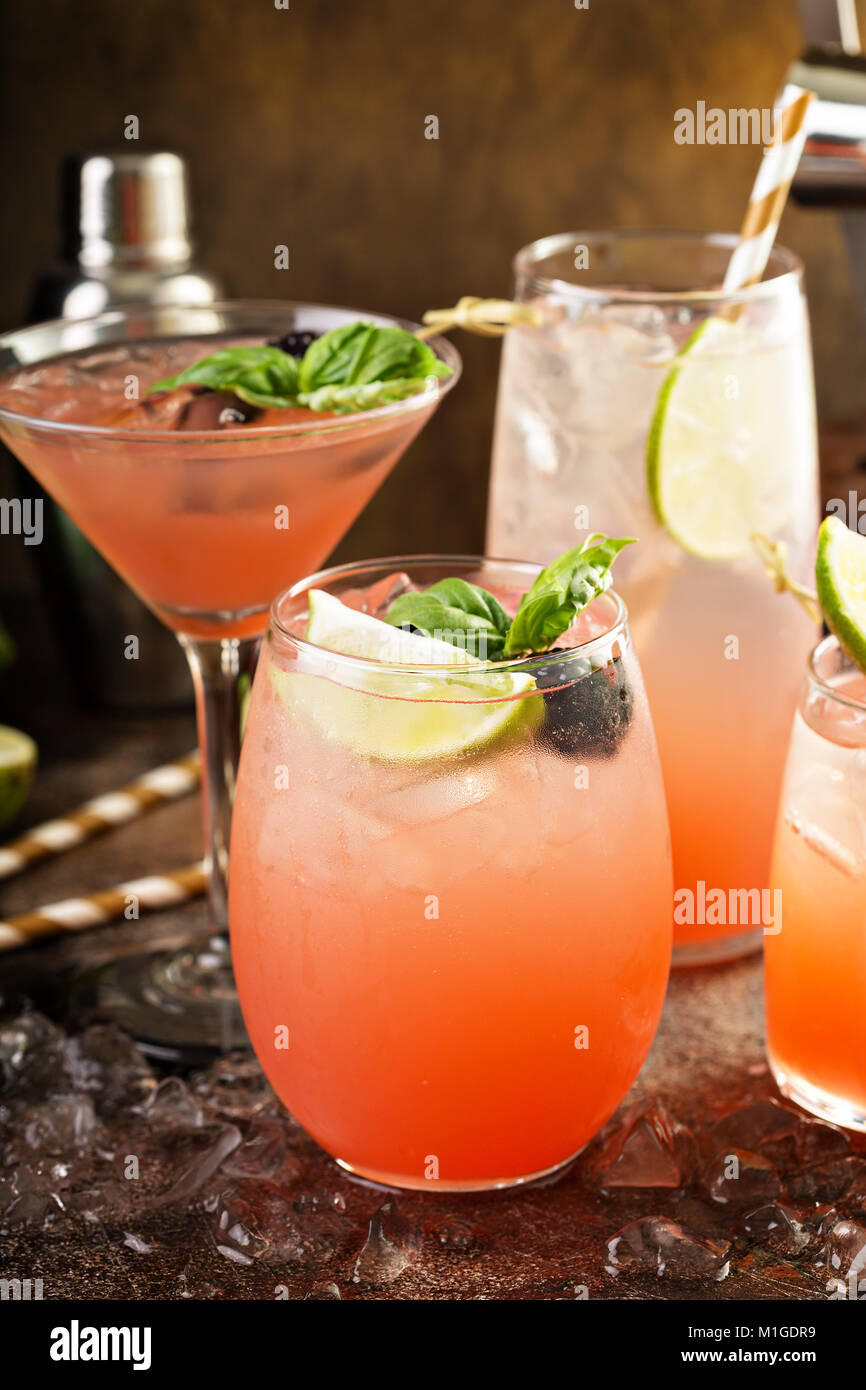 Grapefruit and lime cocktails in different glasses and bartender tools ...