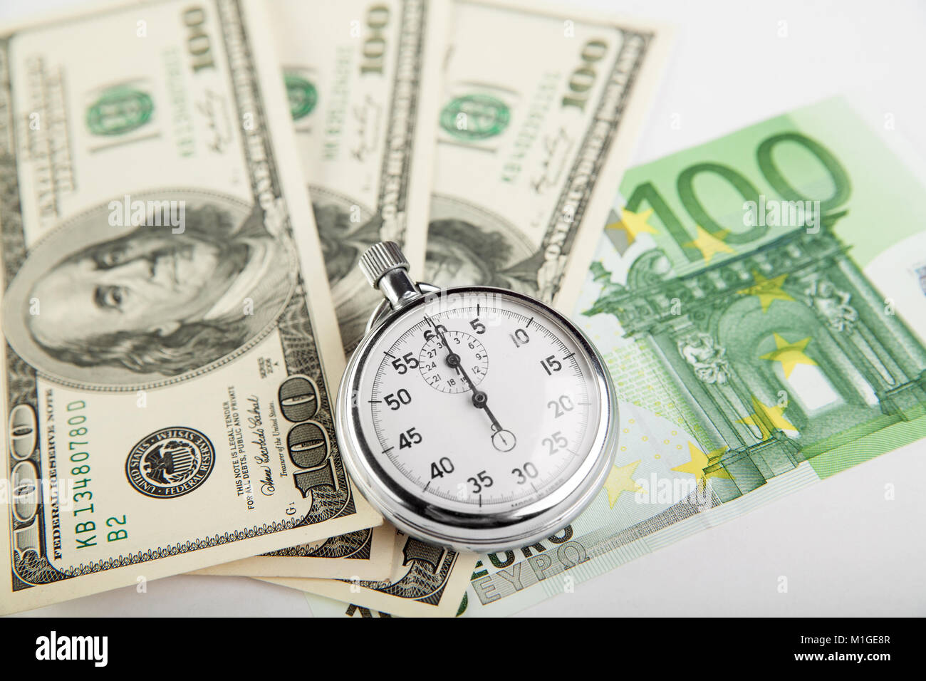 Time is money - stopwatch on bills. Concept Stock Photo - Alamy