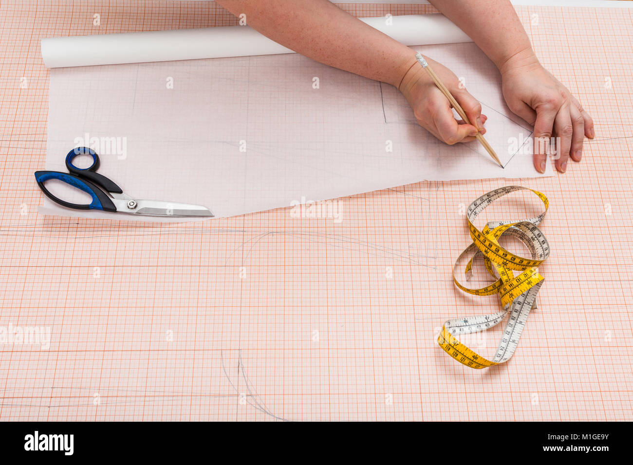 tailor copies the hand drawn clothing pattern on tracing paper Stock ...