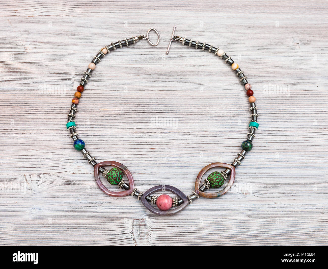 top view of handmade necklace from natural gemstones on wooden table ...