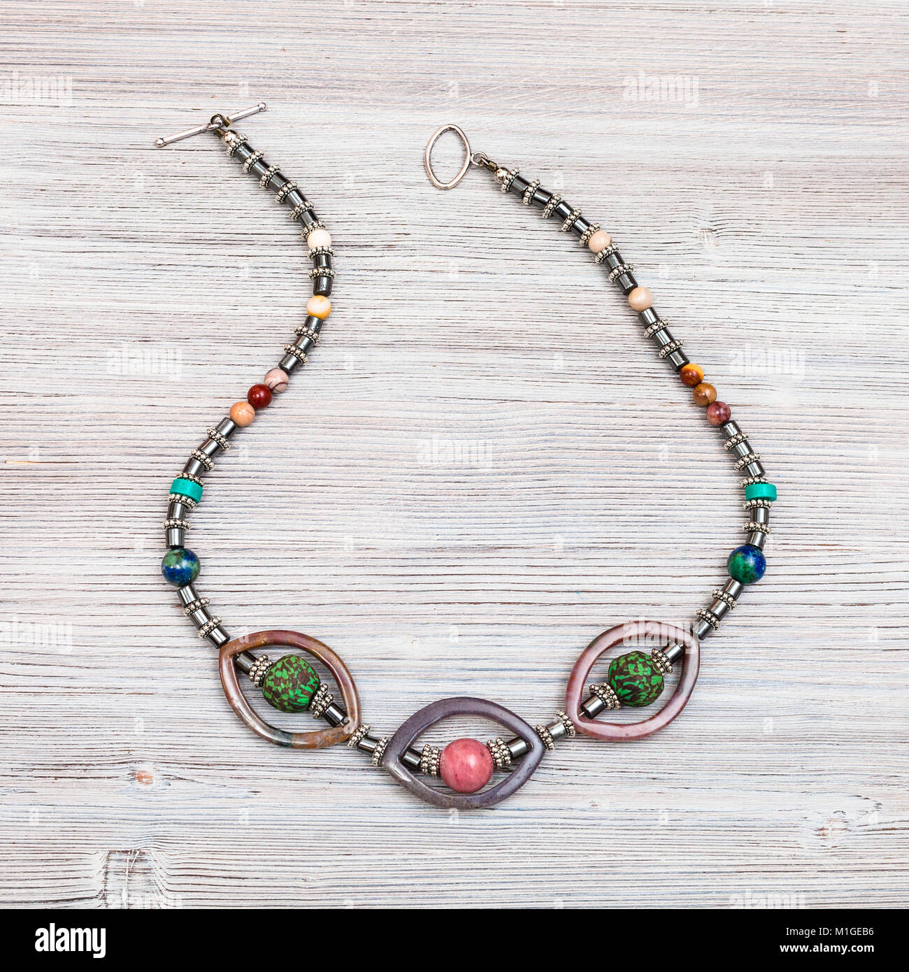 top view of handmade string of beads from natural gemstones on wooden ...