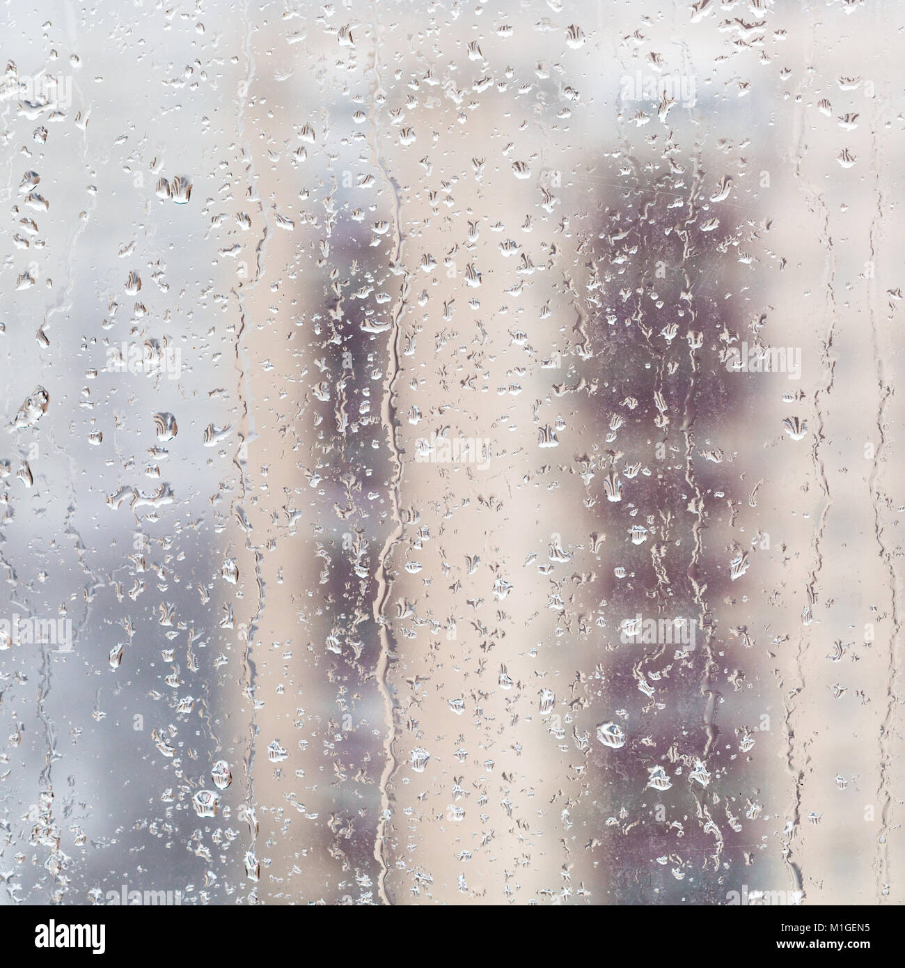 urban background - melting snow on home window glass (focus on water ...