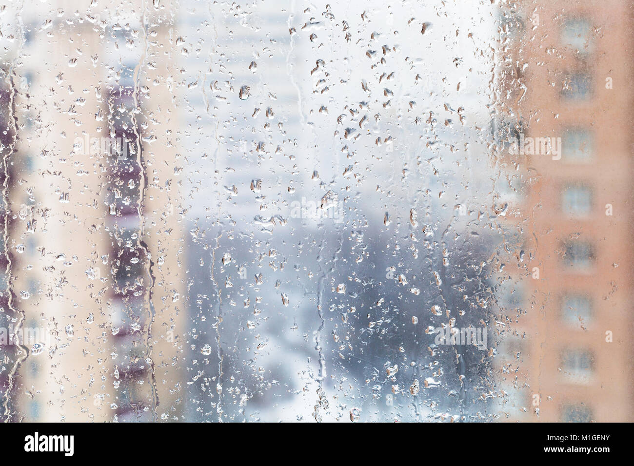 urban background - rain drops on home window glass (focus on water ...