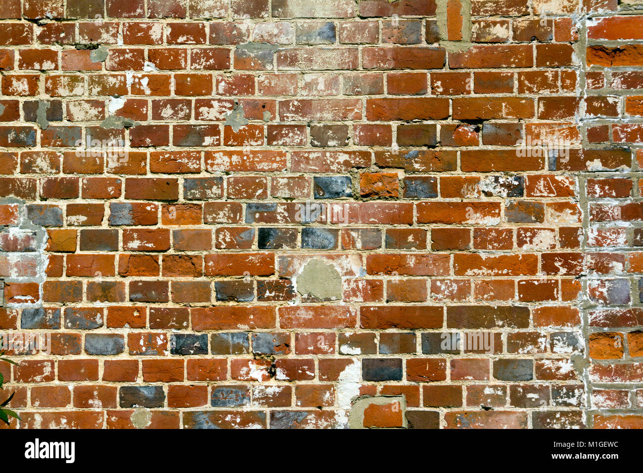Old badly damaged and badly repaired red brick wall close up full frame ...