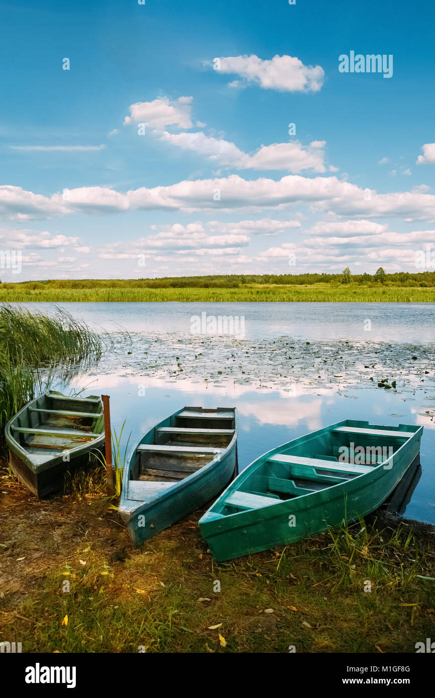 Three wooden boats moored to the bank of the river. Nobody Stock Photo ...