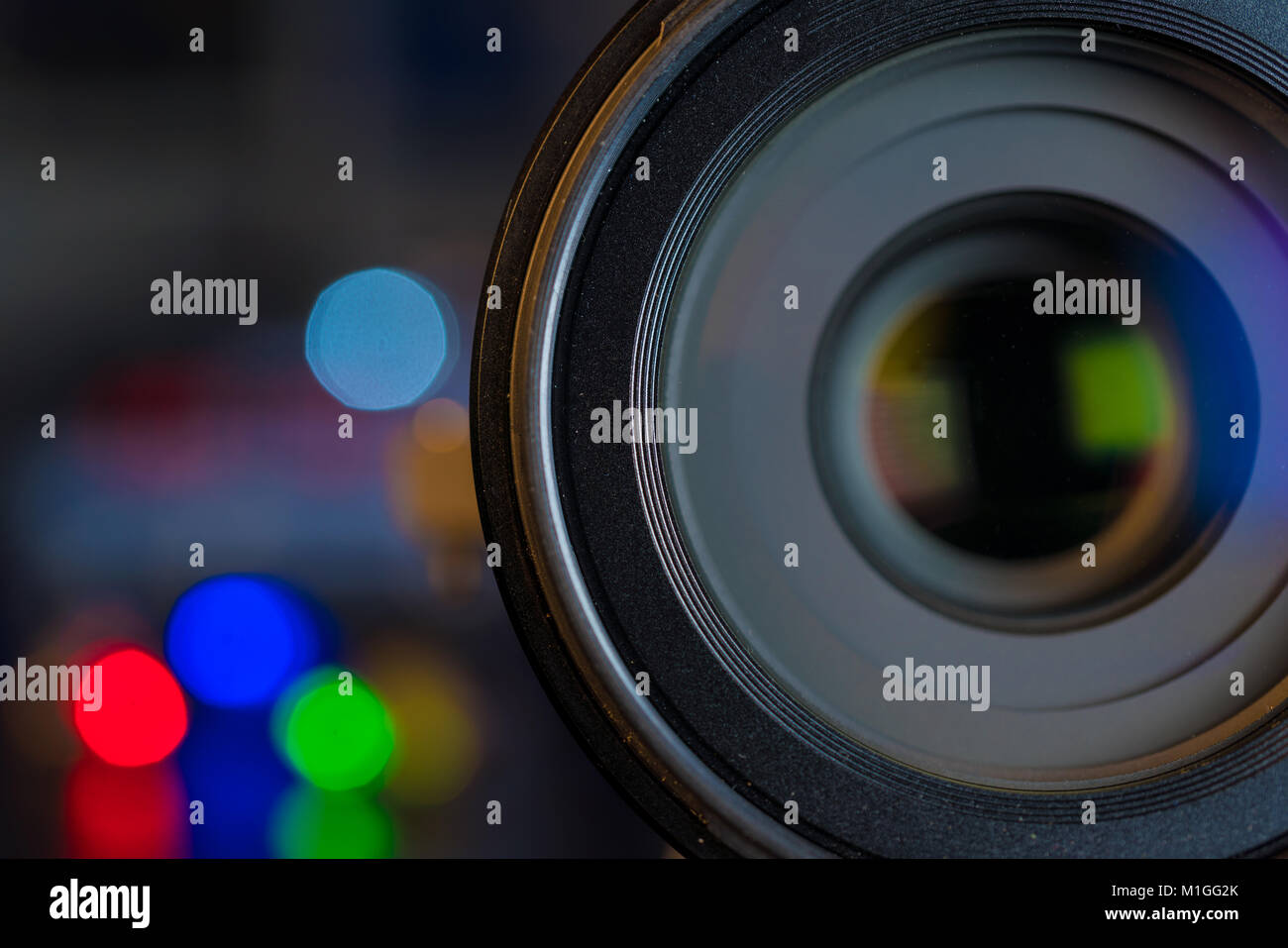 The photo or videocamera lens on dark background with lense reflections ...