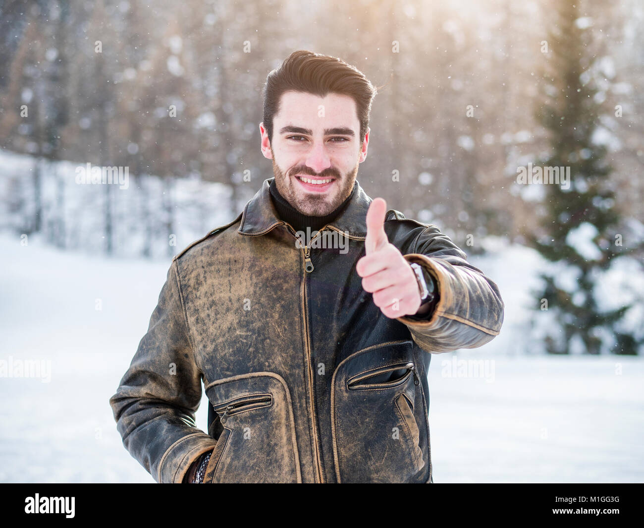 Attractive happy young man smiling, doing thumb up sign with his hand ...