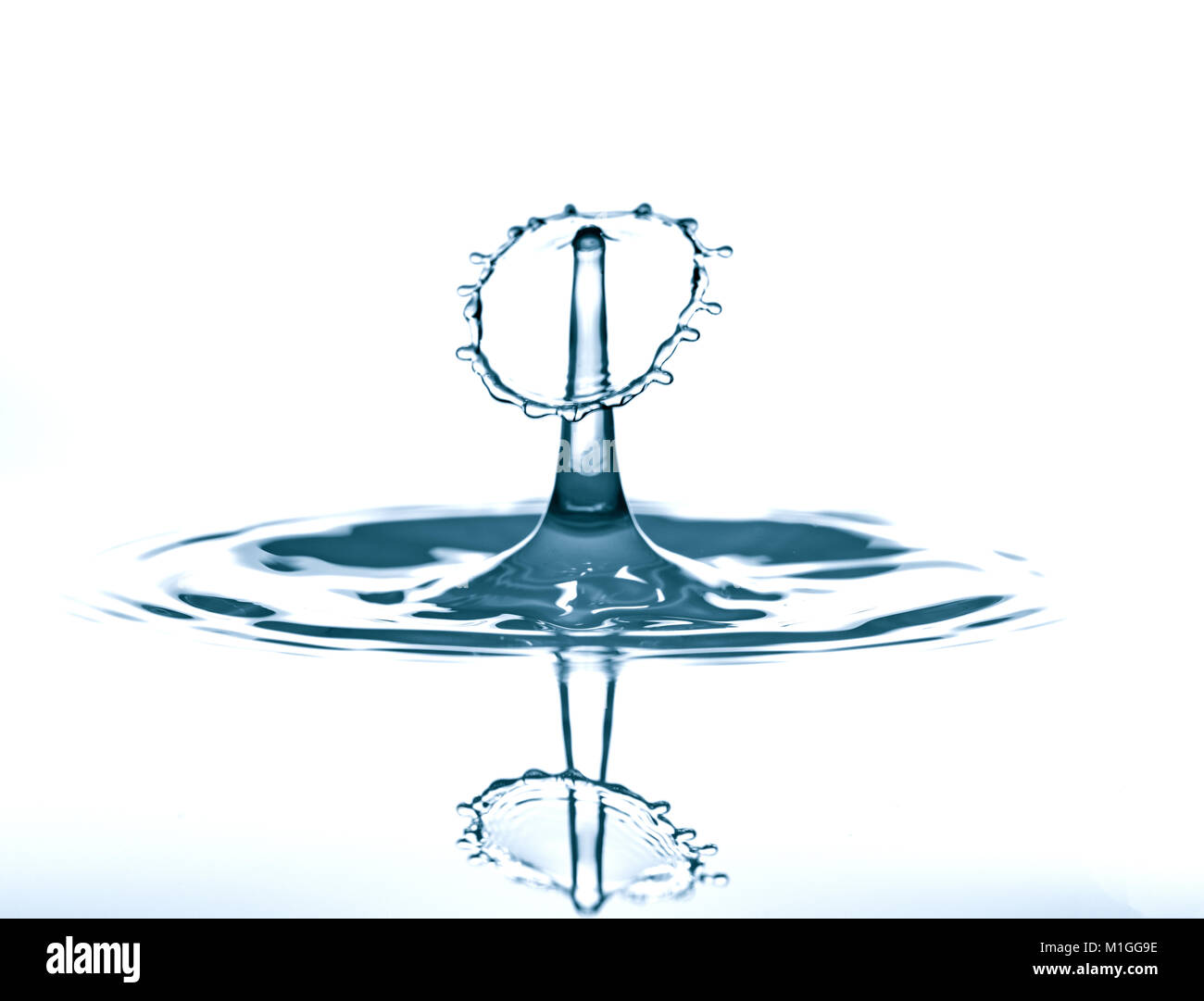 Splash and crown on rippled blue liquid or water surface . Water splash ...