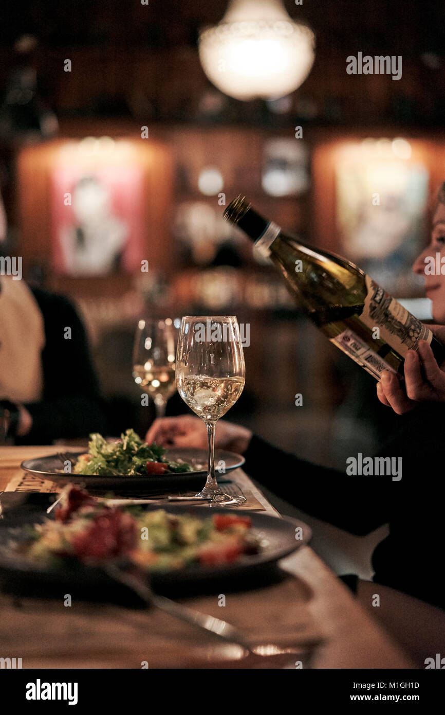 waiter pours alcoholic beverages in the restaurant Stock Photo - Alamy