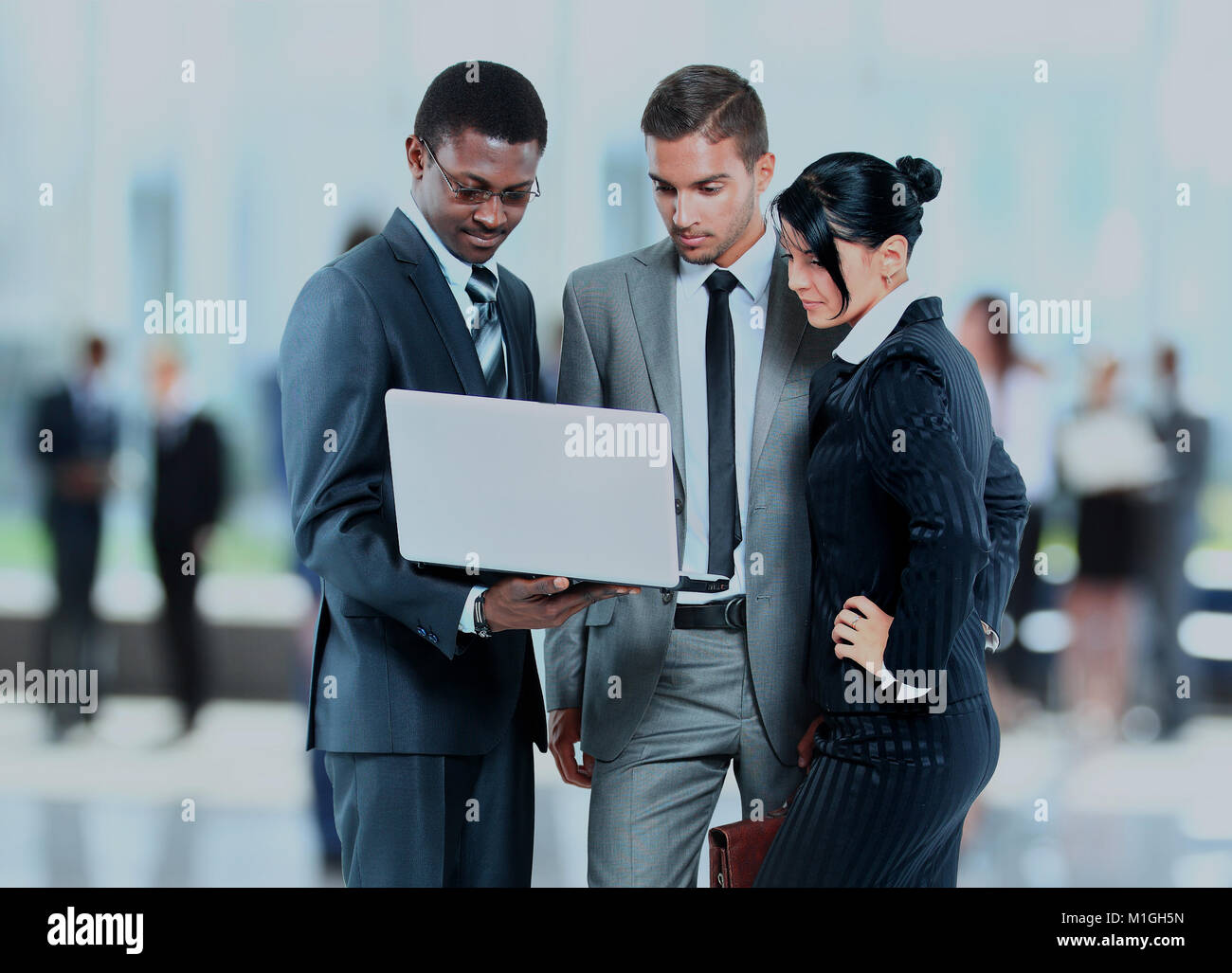 Happy business man holding a modern laptop computer with his team Stock ...