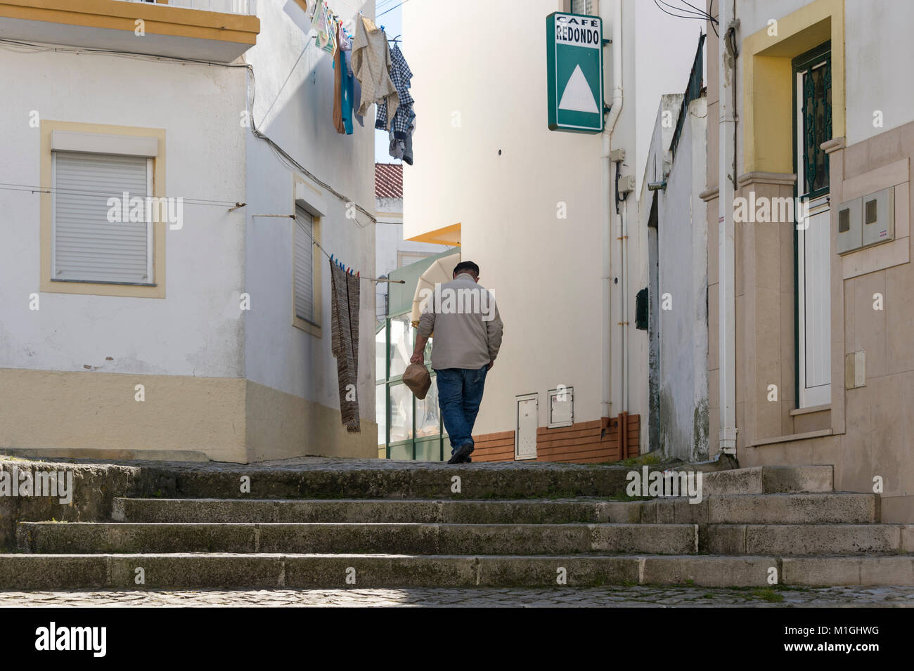 man walking through the narrow streets of Sitio, Nazare. traditional ...