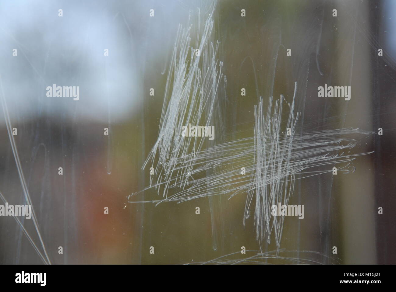 scratchings in a window with blurred background: green blue Stock Photo ...