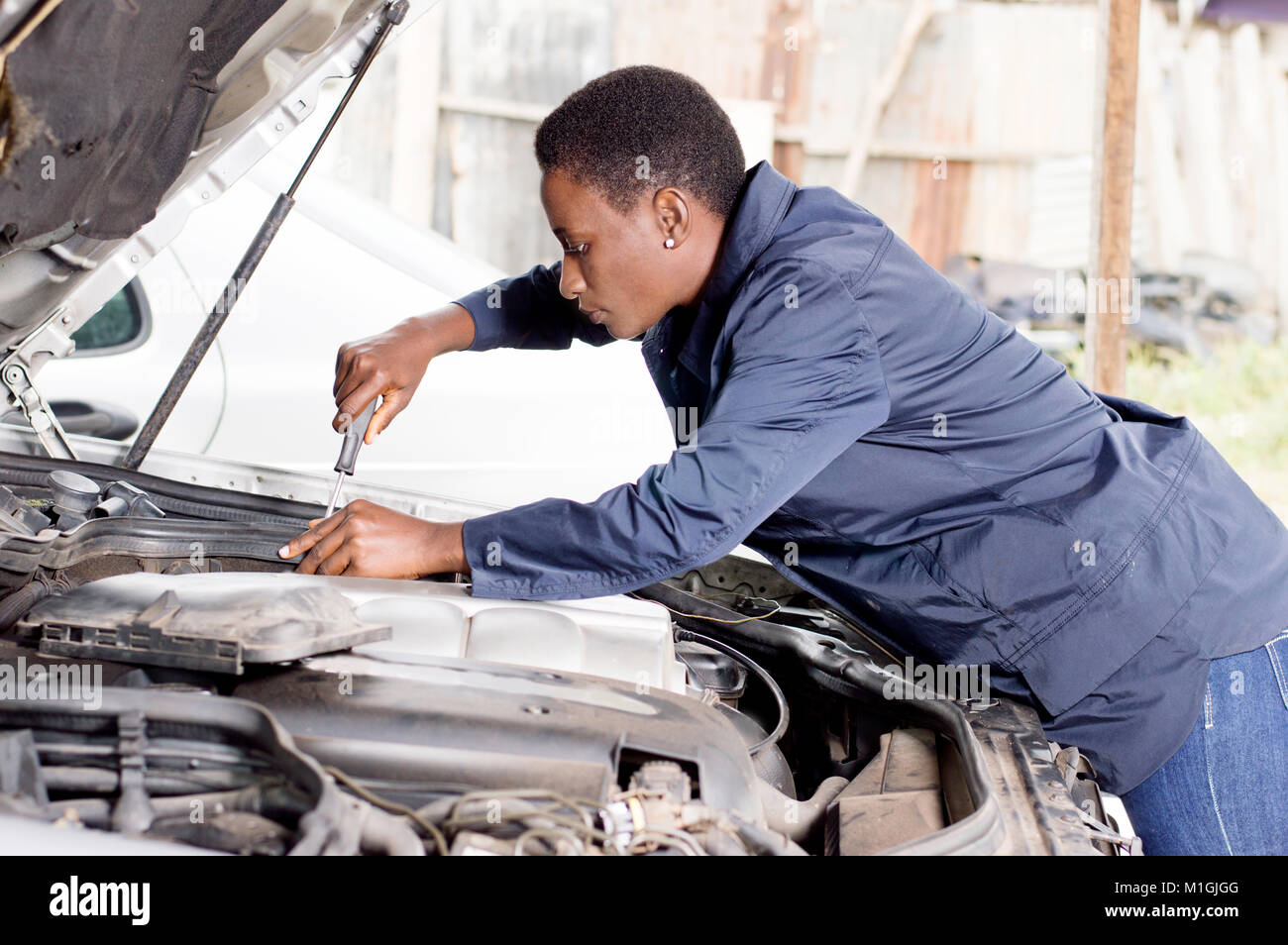 Mechanic repairs the engine of a car in her workshop Stock Photo - Alamy