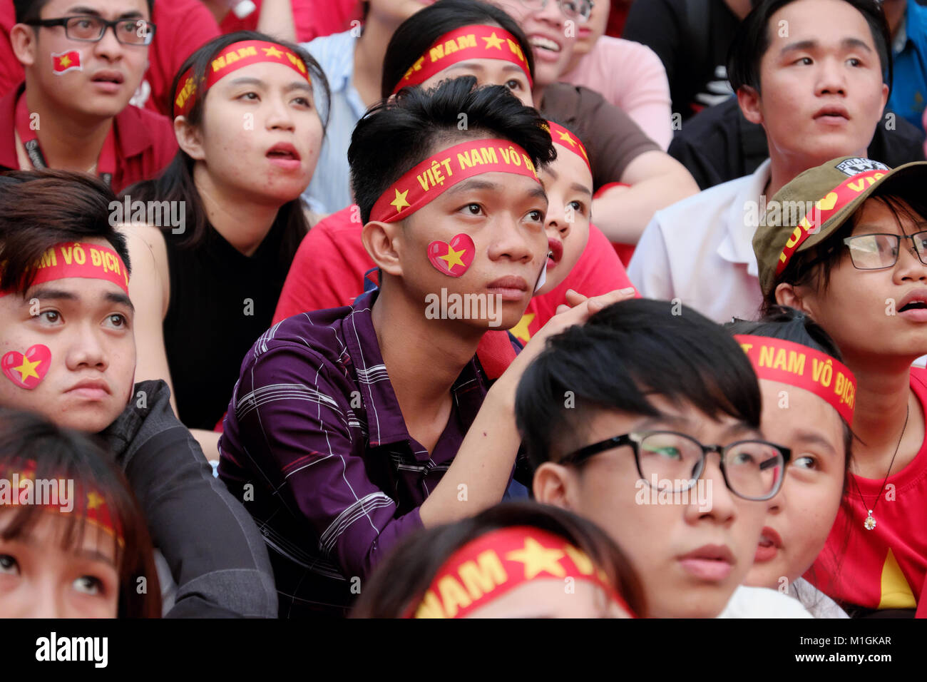 Portrait of Vietnamese football fans sit and watch AFC U23 soccer final ...