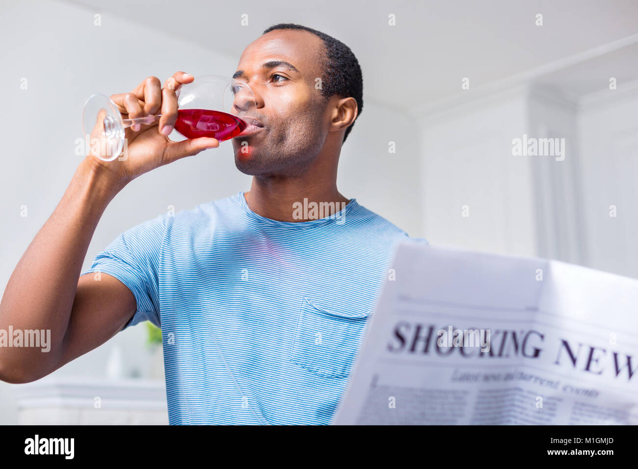 Nice pleasant man drinking alcohol Stock Photo - Alamy