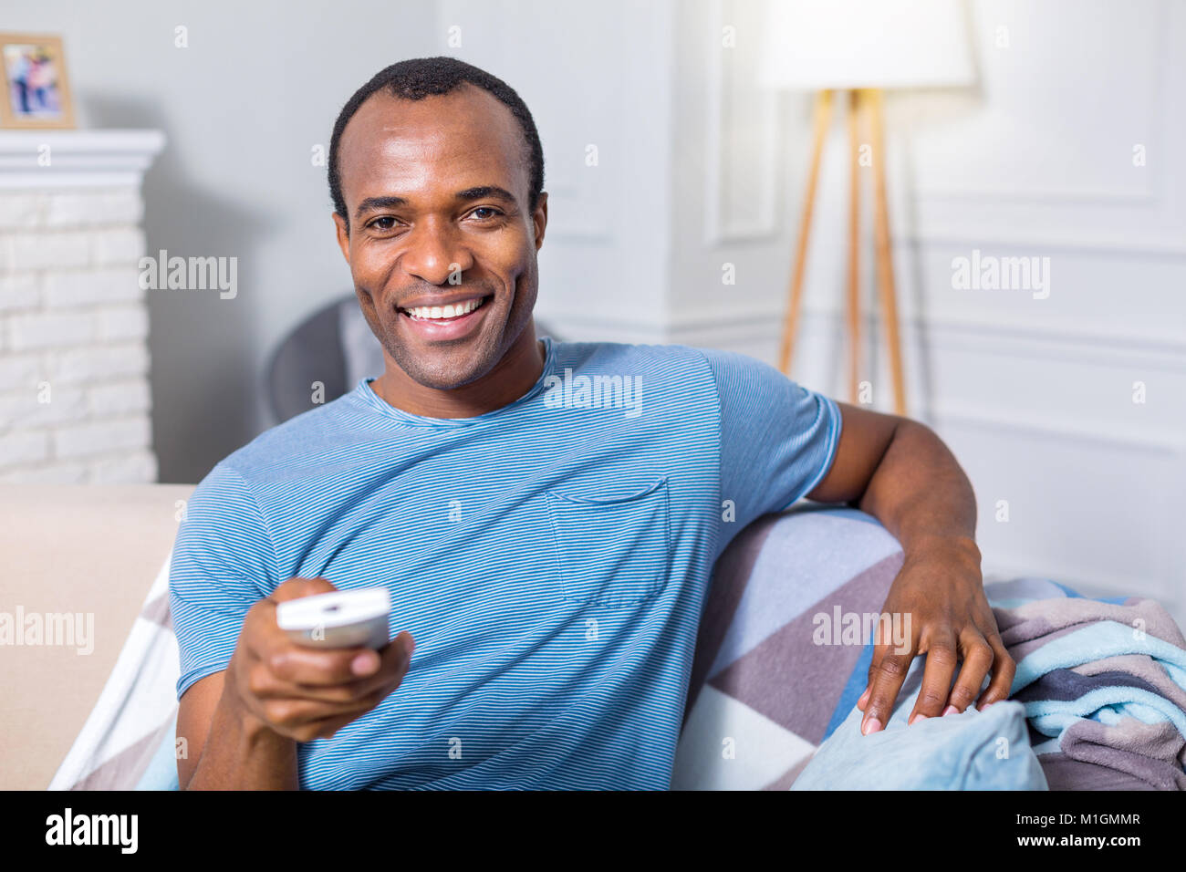 Happy nice man sitting in front of the TV screen Stock Photo - Alamy