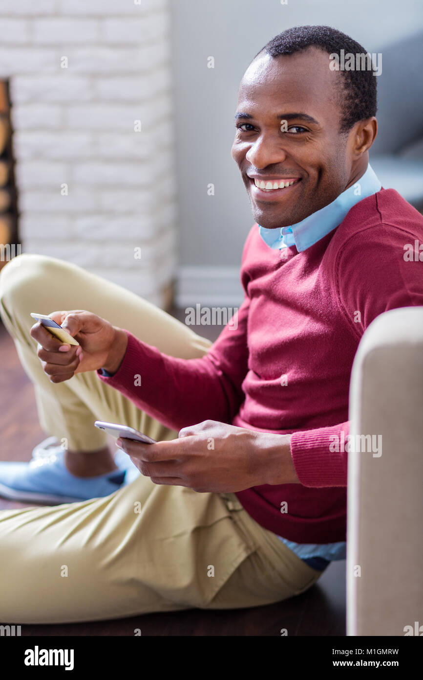 Cheerful nice man using mobile banking system Stock Photo - Alamy