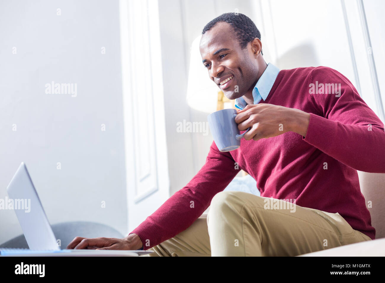 Joyful happy man drinking tea Stock Photo - Alamy