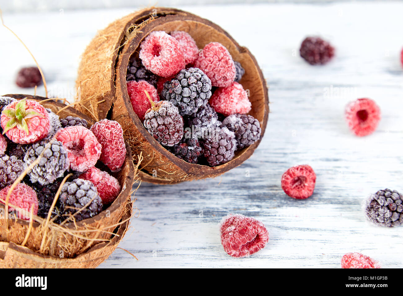 Frozen black and red raspberries in coconut bowl Stock Photo - Alamy
