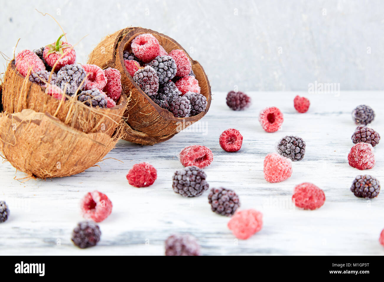 Frozen black and red raspberries in coconut bowl Stock Photo - Alamy