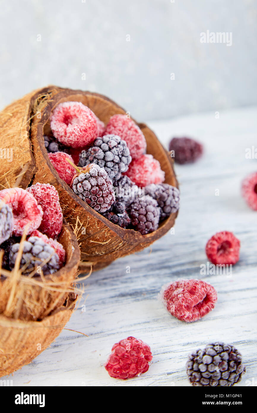 Frozen black and red raspberries in coconut bowl Stock Photo - Alamy