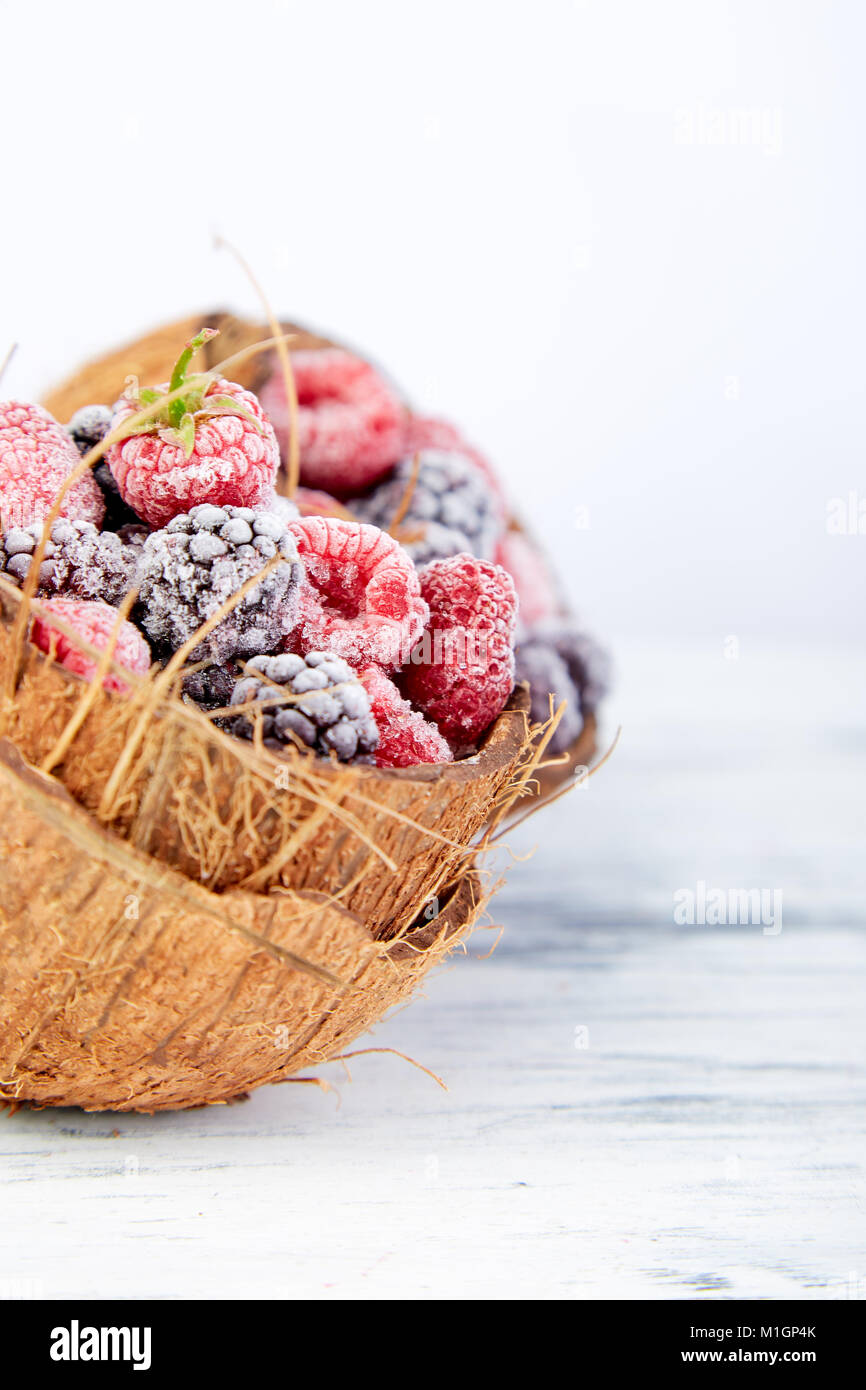 Frozen black and red raspberries in coconut bowl Stock Photo - Alamy