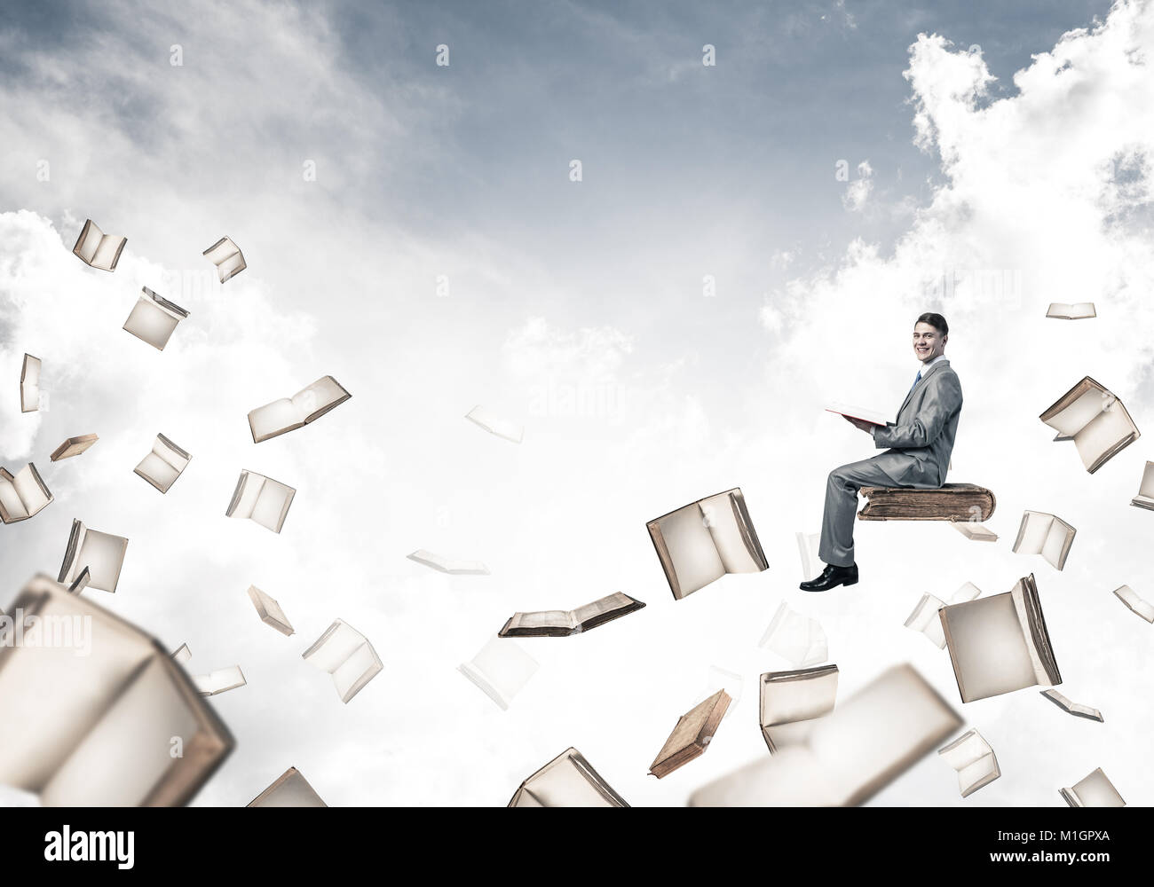 Man reading book and many of them flying in air Stock Photo - Alamy