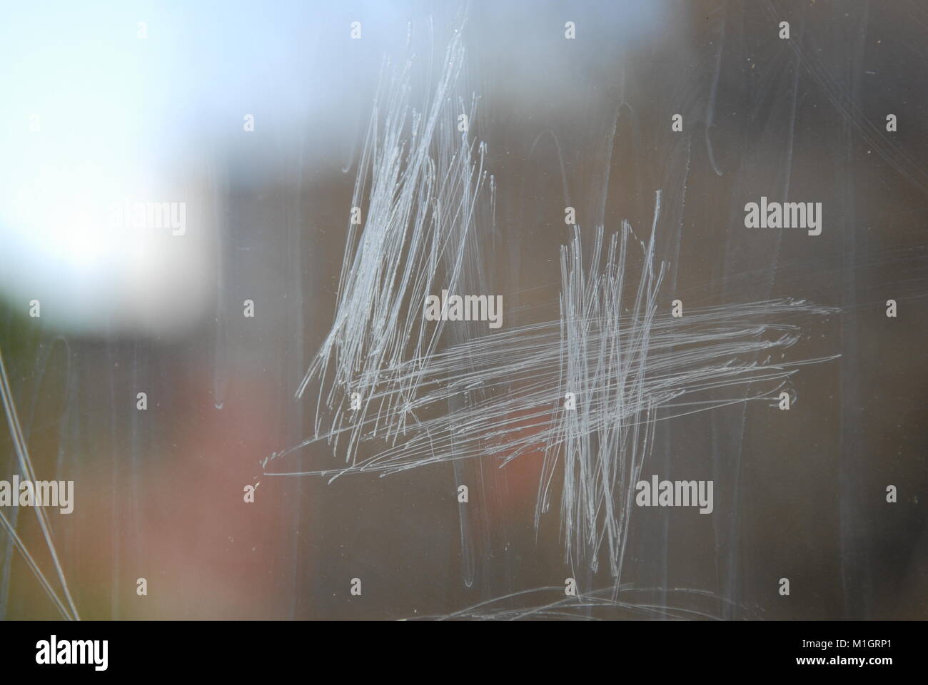 scratchings in a window with blurred background:blue-red colored Stock ...