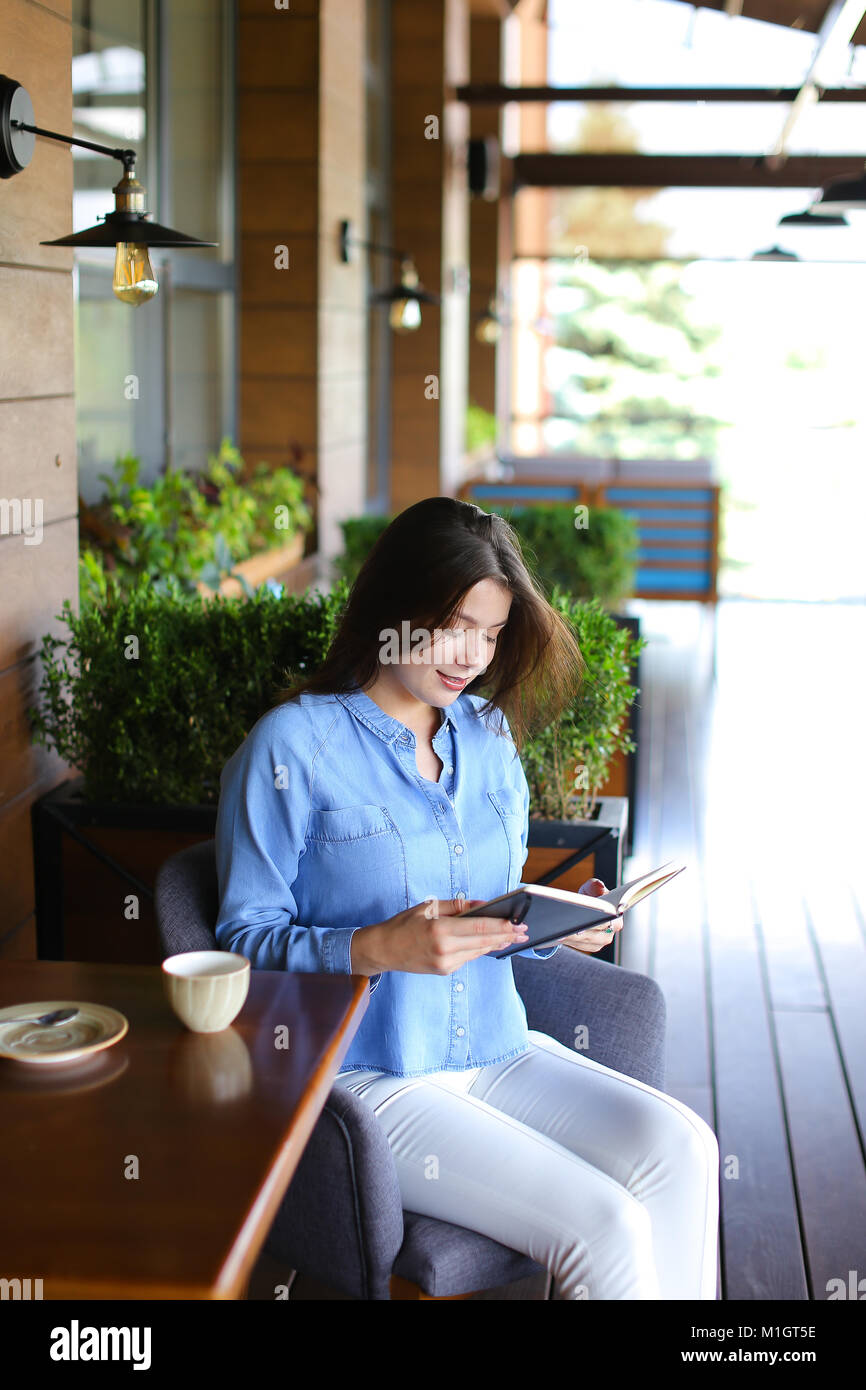 Beautiful girl reading diary at cafe Stock Photo - Alamy