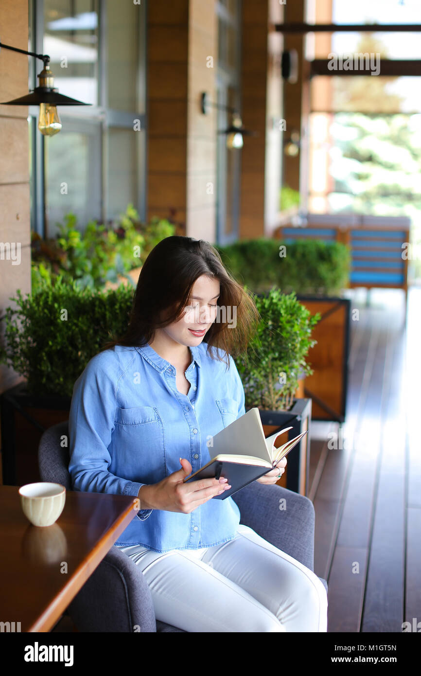 Beautiful girl reading diary at cafe Stock Photo - Alamy
