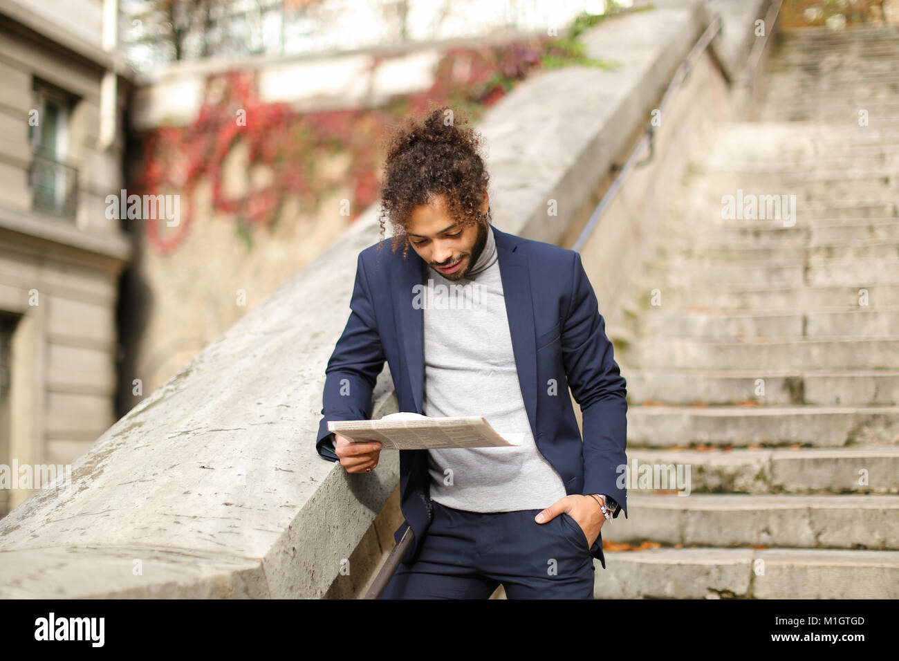 Young male model reading newspaper on open air Stock Photo - Alamy