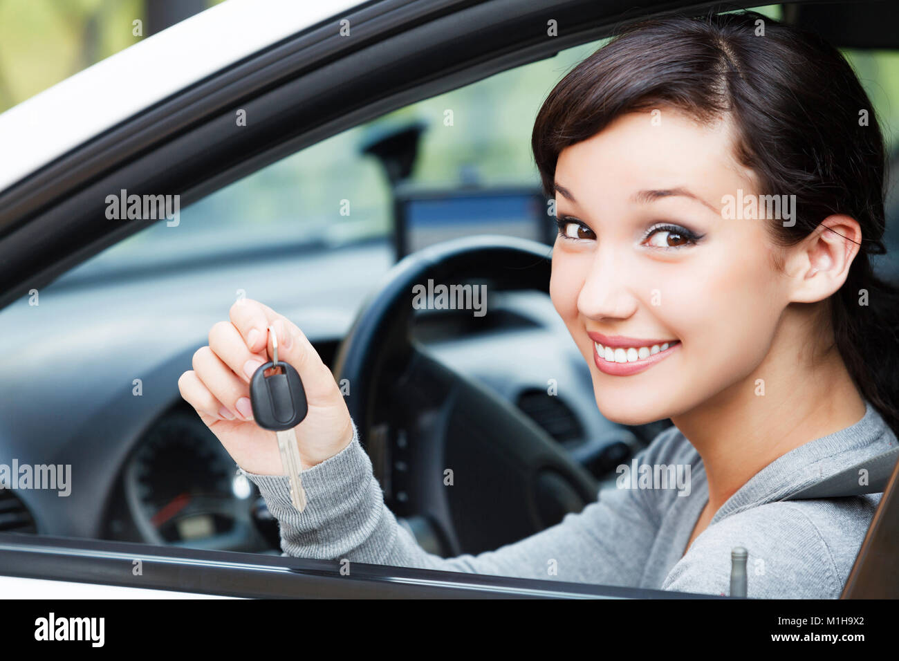Happy female driver showing car key Stock Photo - Alamy