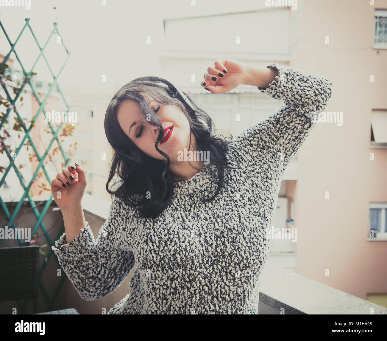 Happy girl dancing outdoor singing and listening music with headphones ...