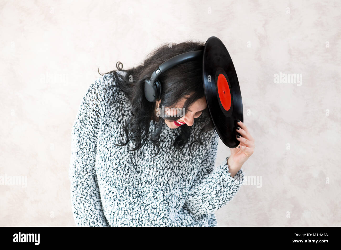 Young brunette pretty woman with vintage vinyl record on her head ...