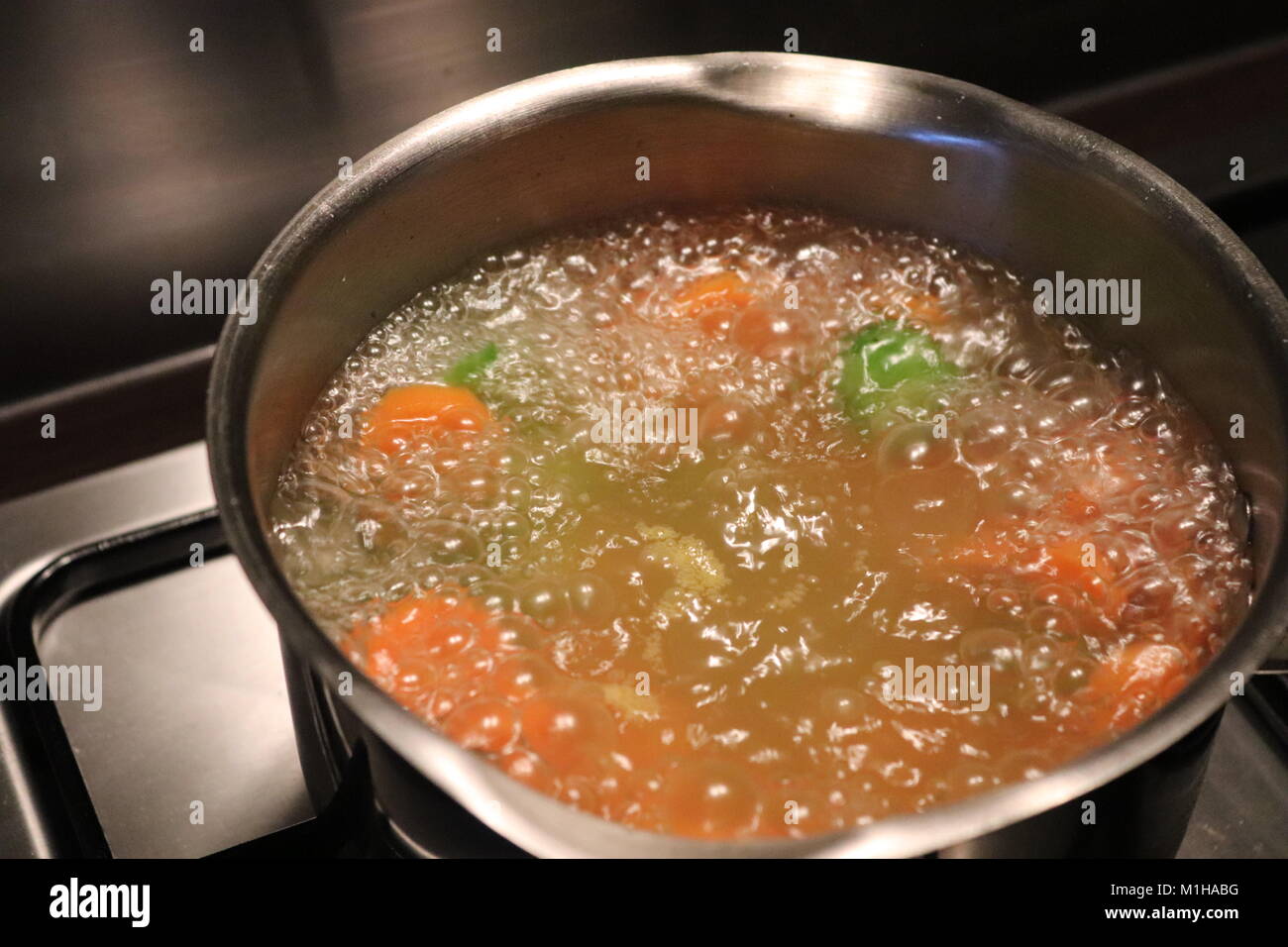 Pan of boiling vegetables Ona gas stove simmer and steam Stock Photo ...