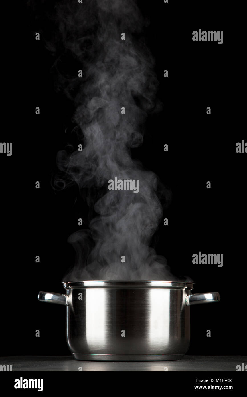 Steaming pot isolated on black background Stock Photo - Alamy