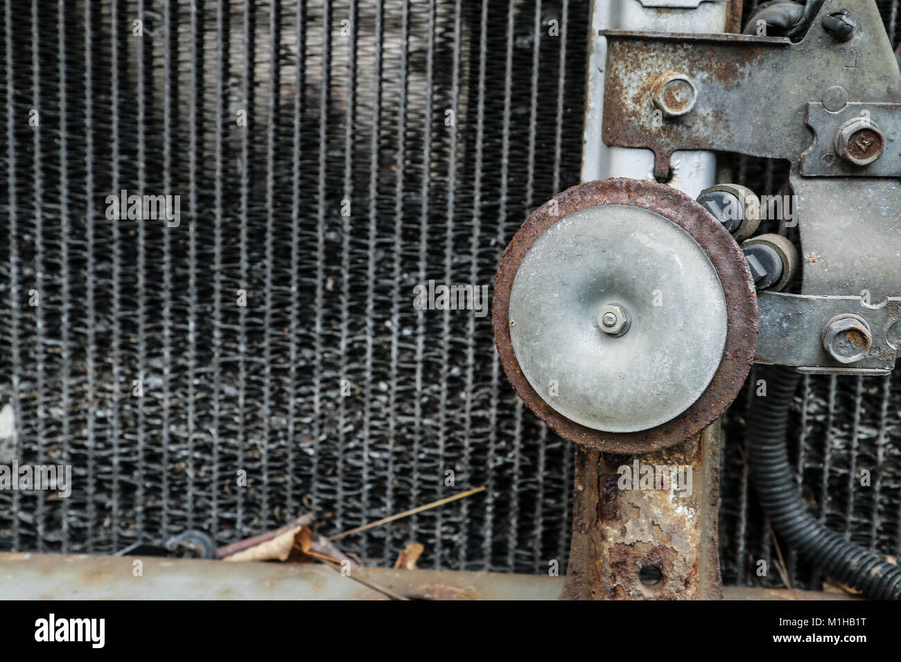 A detail of the old car wreck. The dirty radiator full of mess with a ...