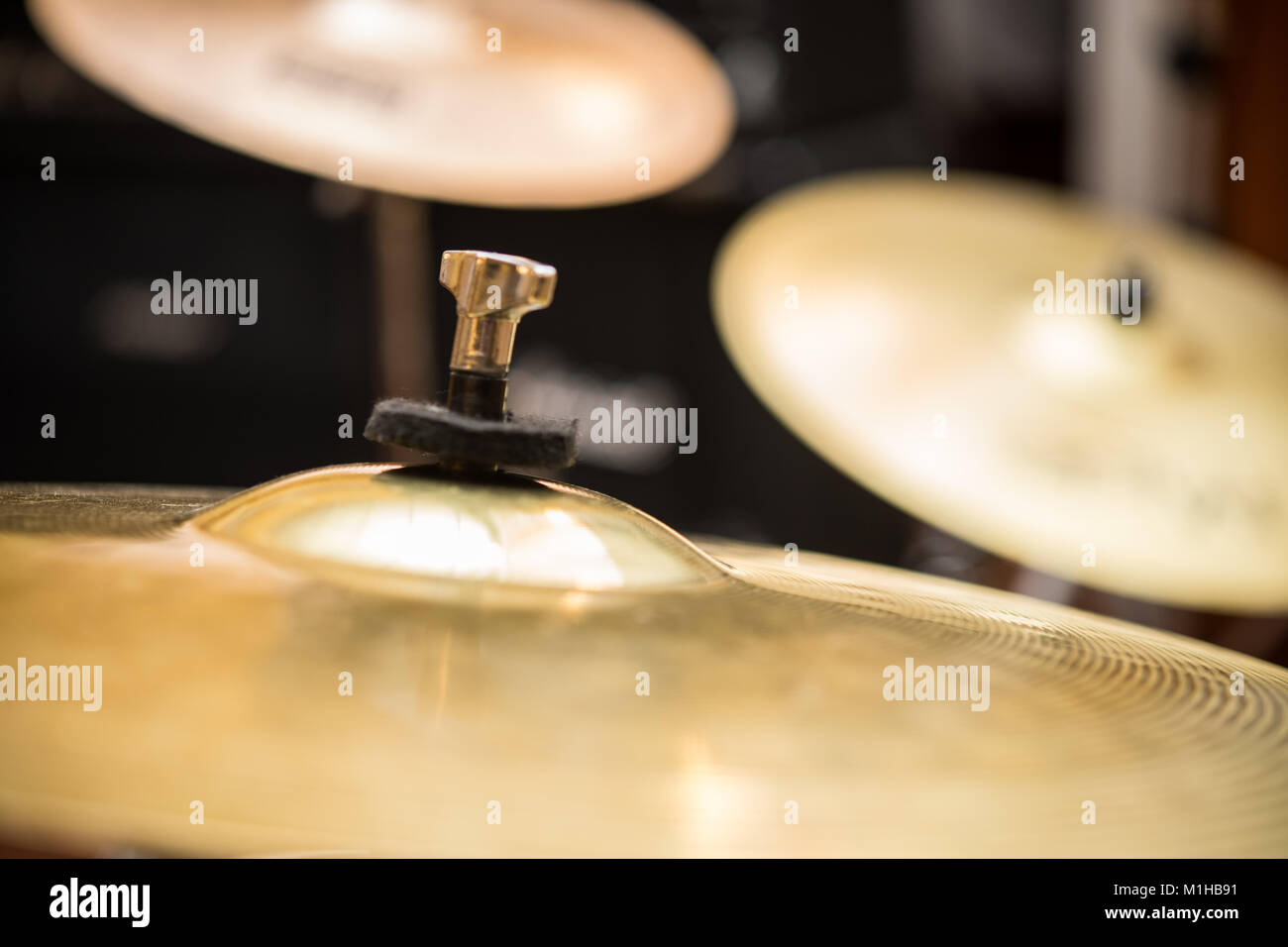 Close up of golden bronze cymbal plate part of drum set out of focus ...