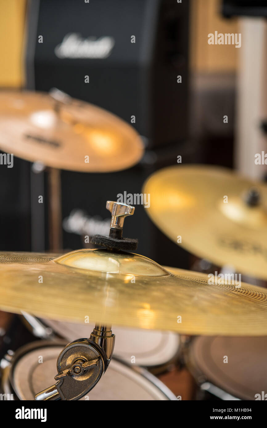 Close up of golden bronze cymbal plate part of drum set out of focus ...