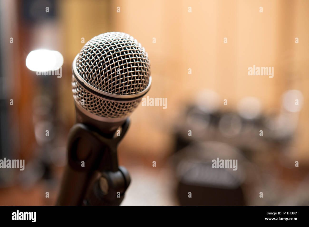 Macro close up of studio microphone with stage lights in background ...