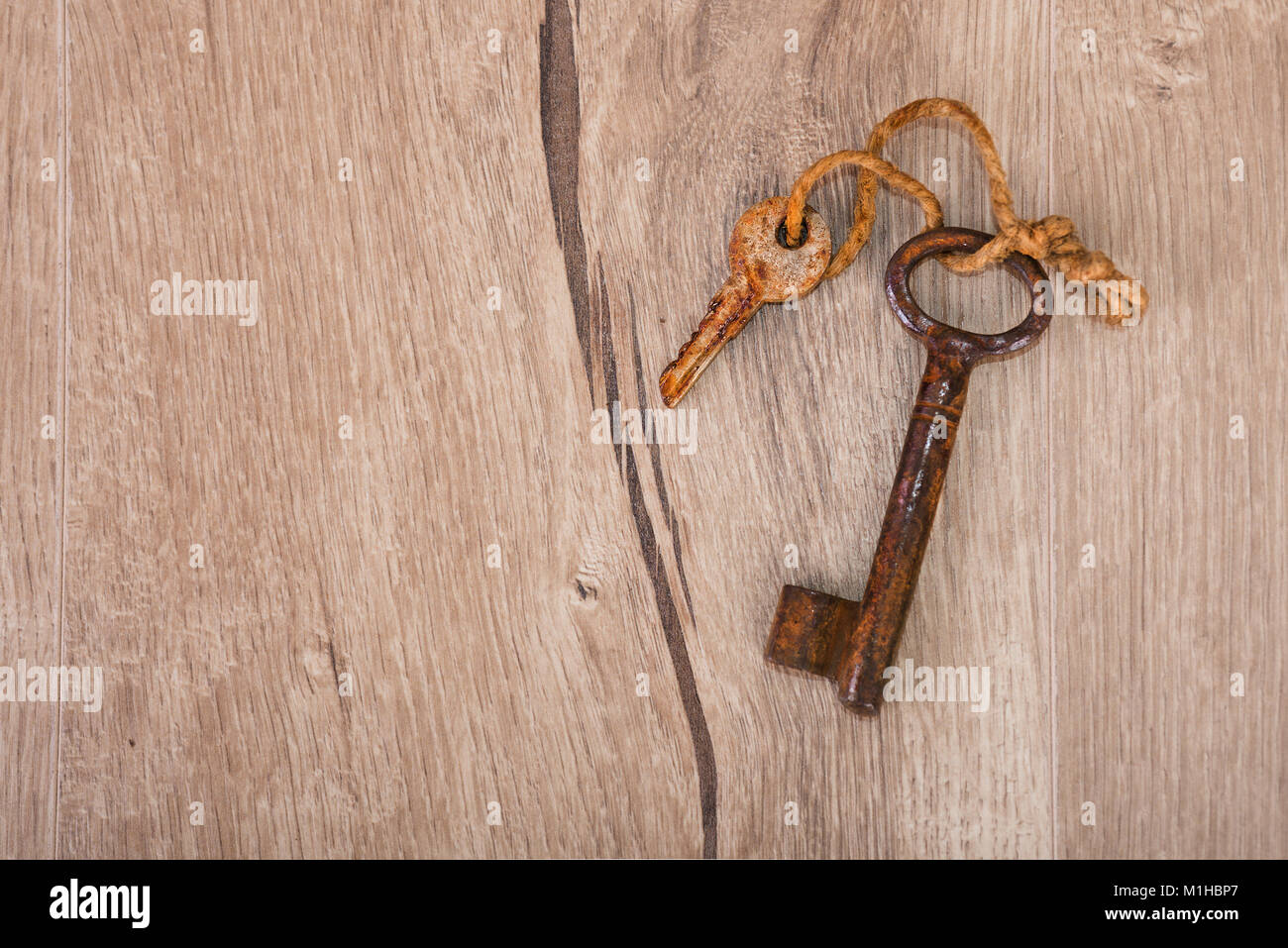 Old rusty keys on a rope on wood background, text space Stock Photo - Alamy
