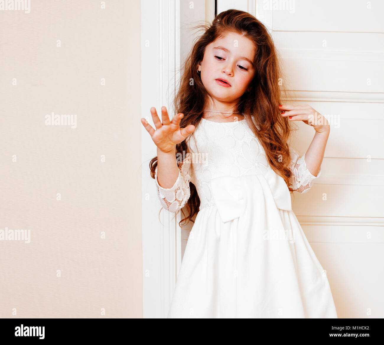 little cute girl at home, opening door well-dressed in white dre Stock ...