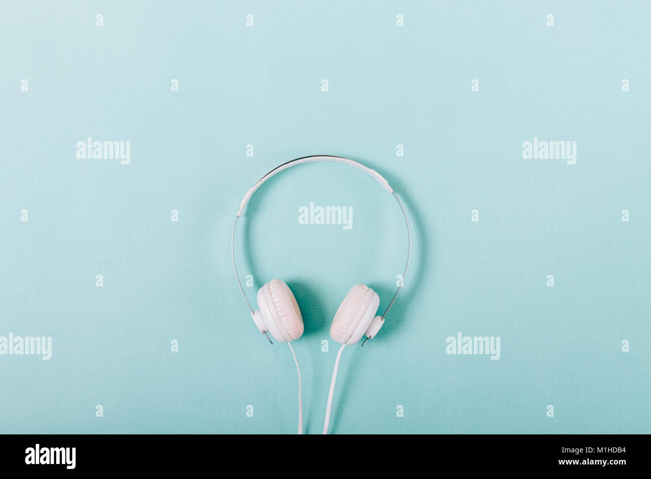 White headphones on a blue table top view Stock Photo - Alamy