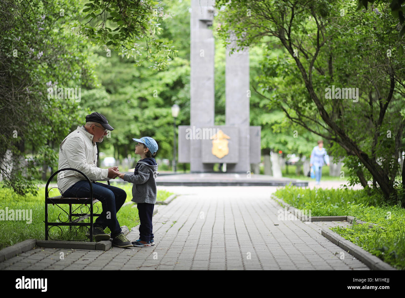 Grandpa is walking with her grandson in a spring park. Grandson Stock ...