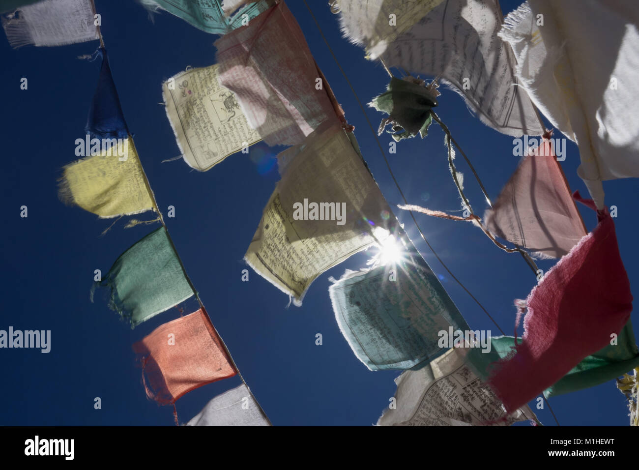 Buddhist prayer flags with Tibetan prayers on the ropes against the ...